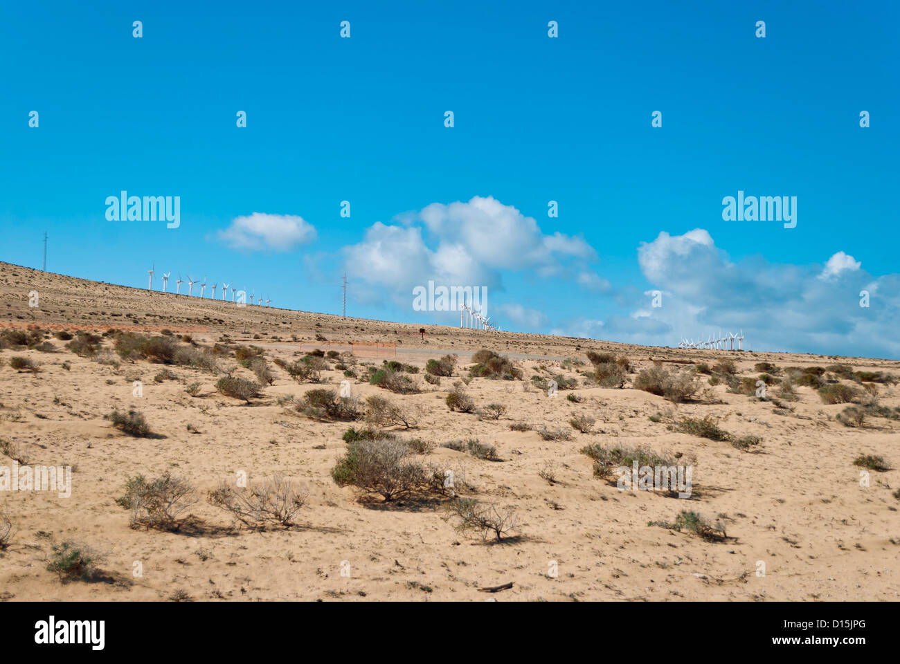 Wind power turbines on blue sky background and sandy lanscape ...