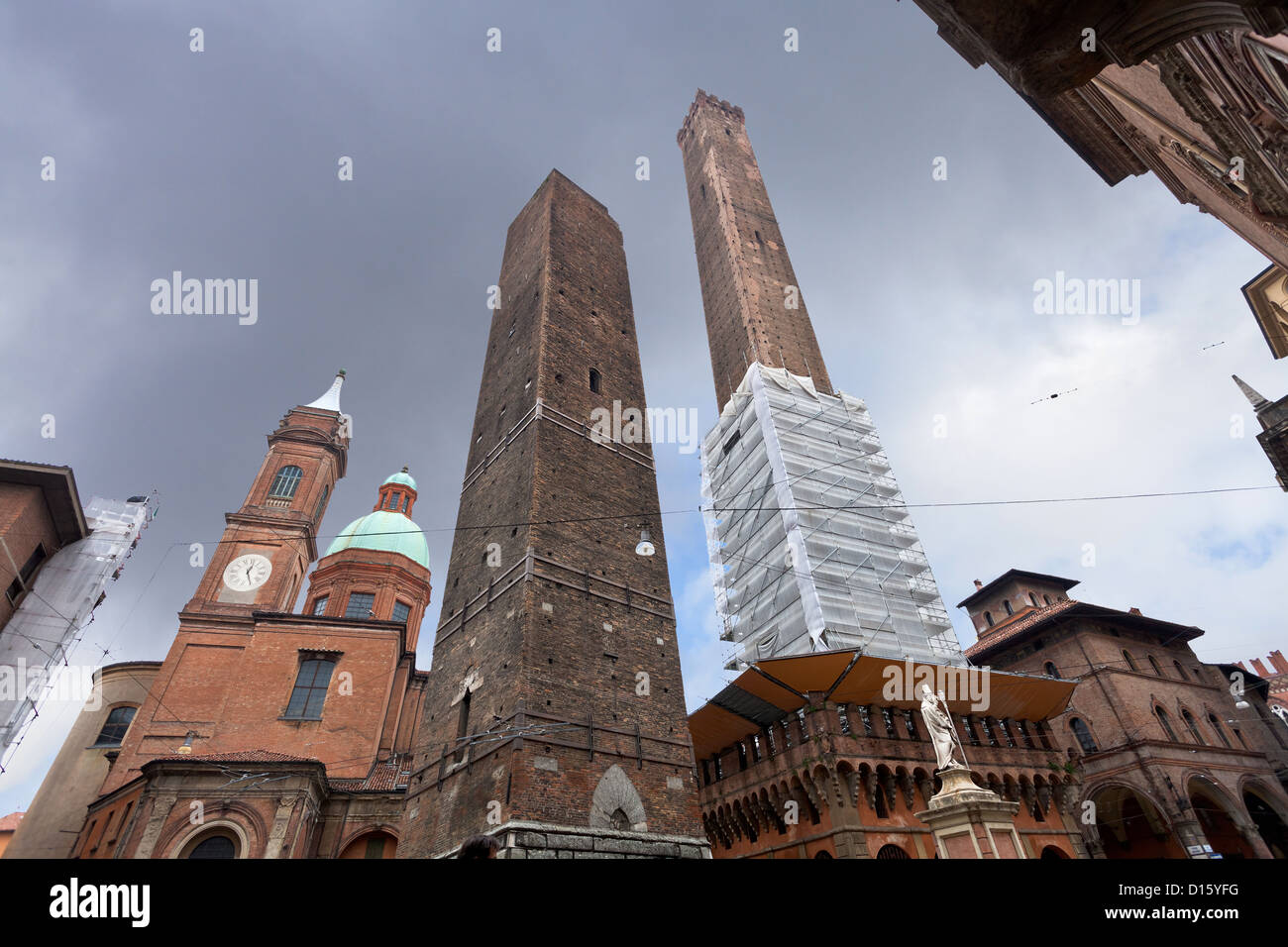 palace and two towers and statue of Saint Petronius under grey sky in ...