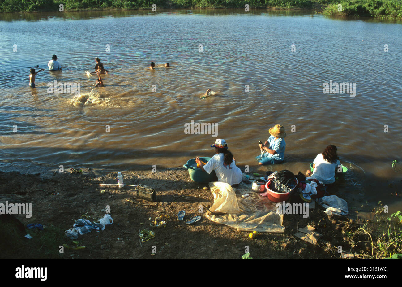 Native indigenous people bathing and washing in a river in the Amazon ...
