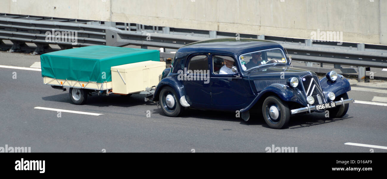 Citroen car 11 CV from 1956 towing trailer driving along M25 motorway ...