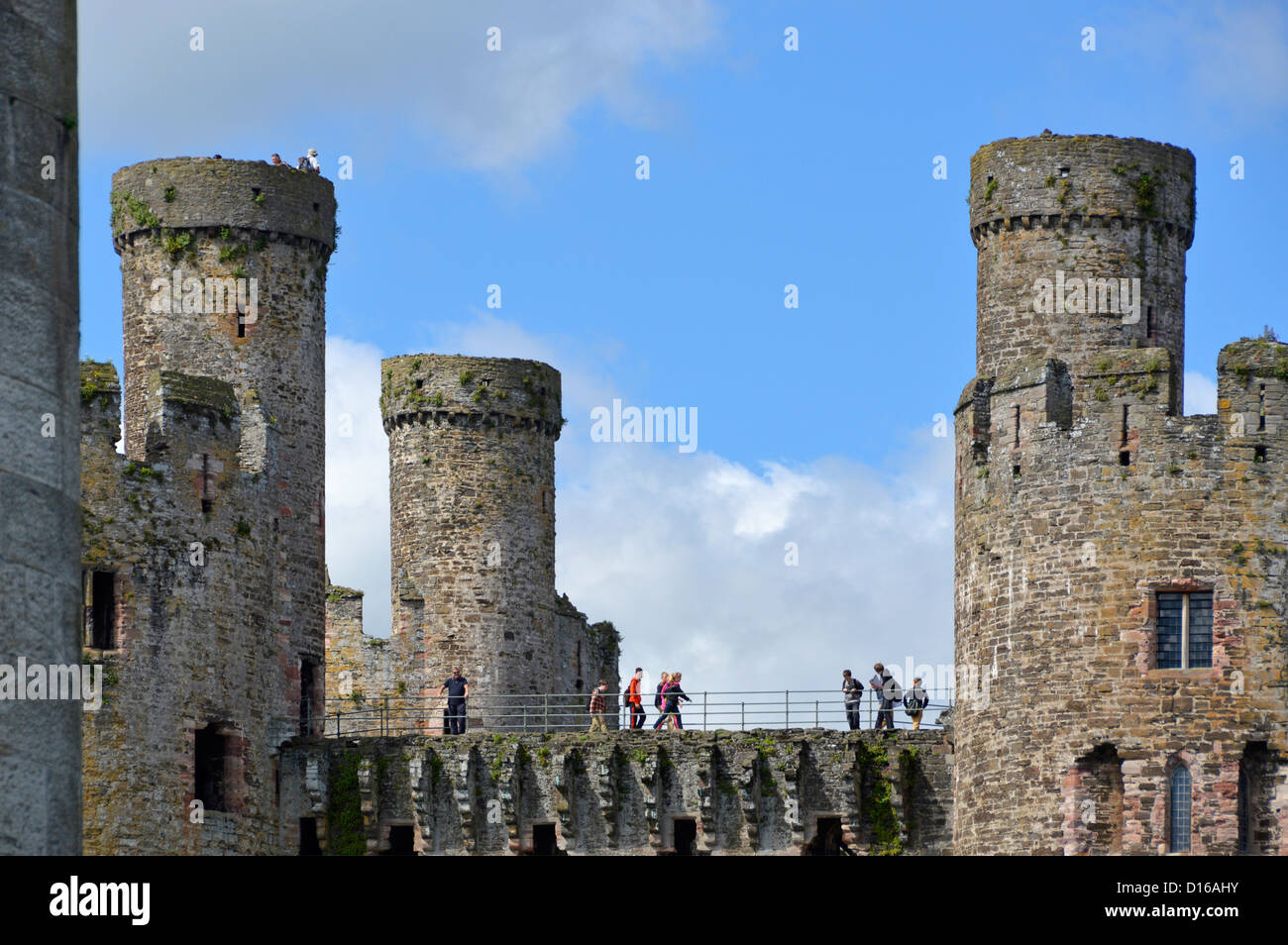 Tourists visiting the walls and towers of medieval historic Conwy ...