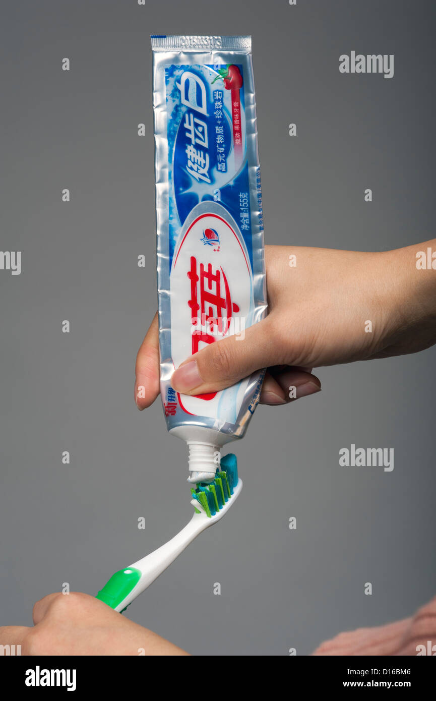 Woman's hand squeezing toothpaste onto a toothbrush Stock Photo - Alamy