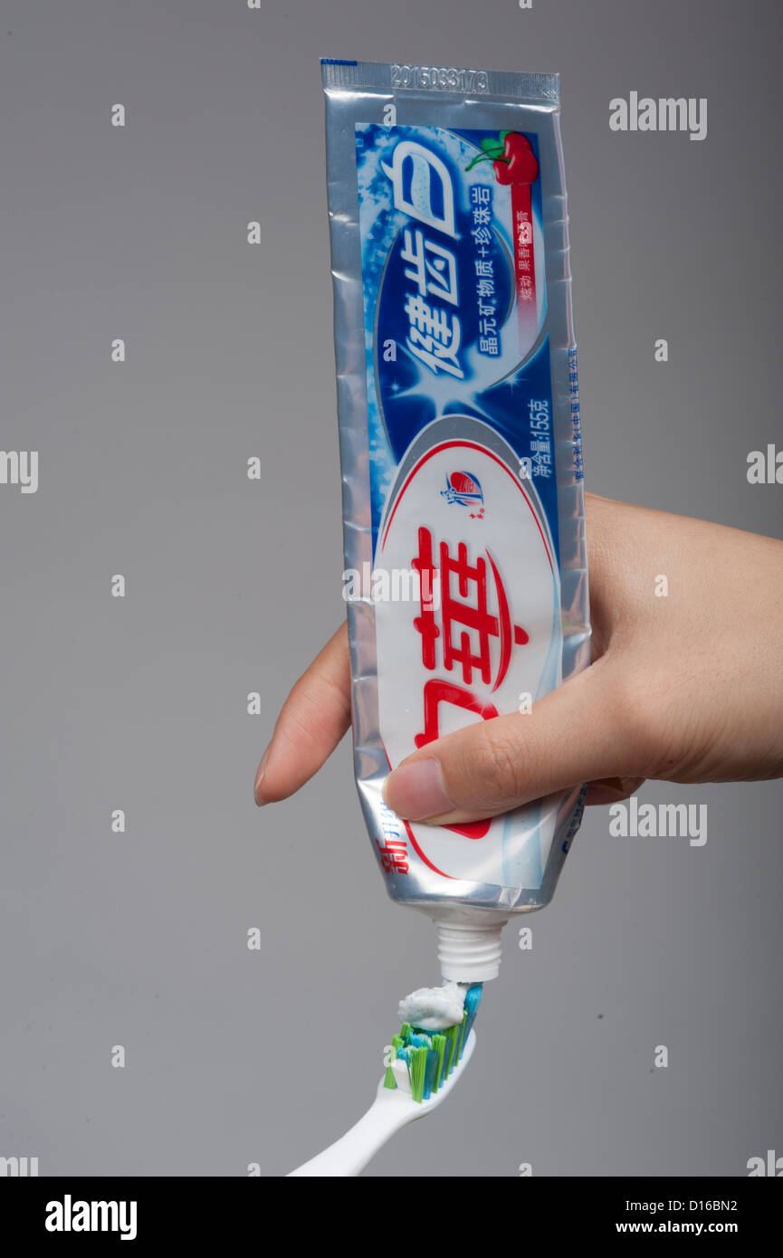 Woman's hand squeezing toothpaste onto a toothbrush Stock Photo - Alamy