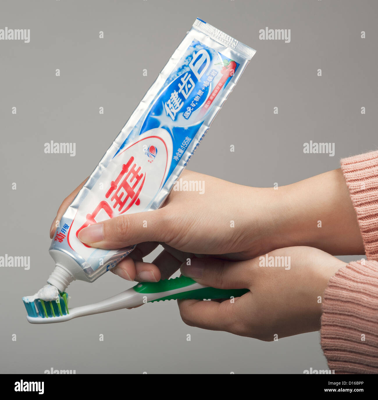 Woman's hand squeezing toothpaste onto a toothbrush Stock Photo - Alamy