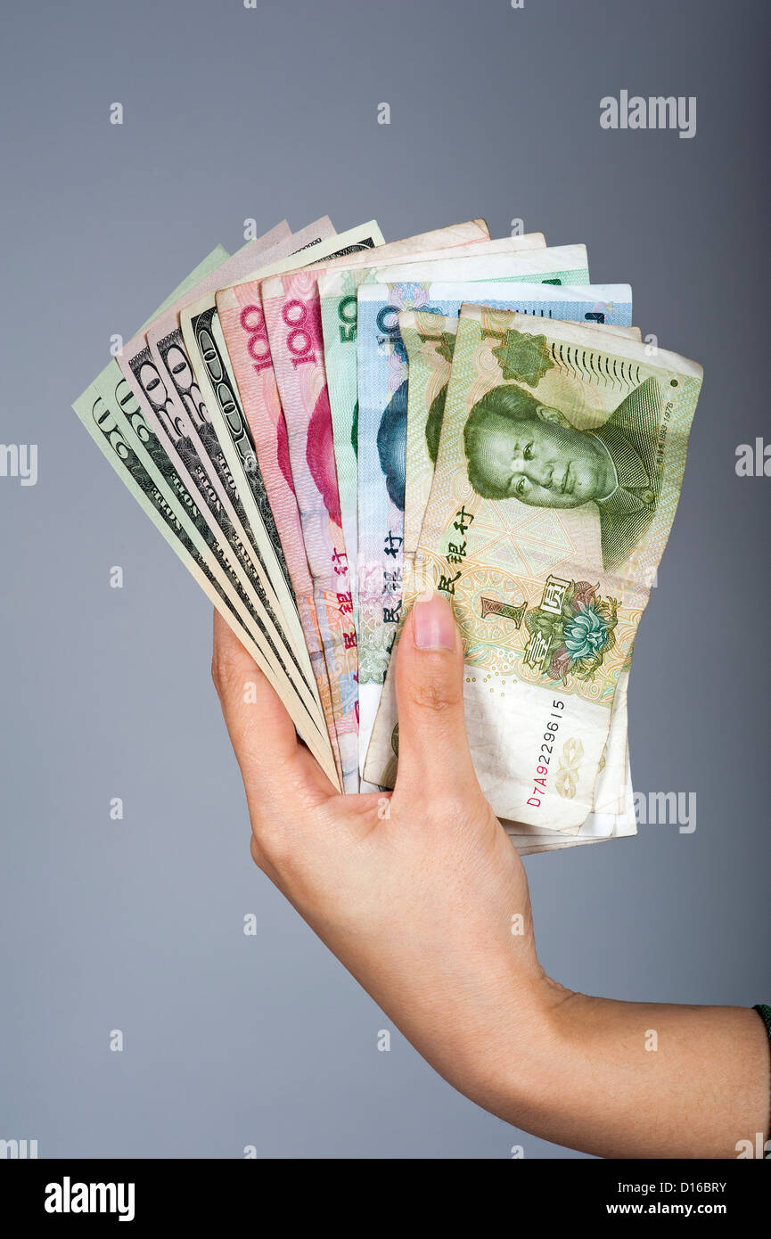 Young woman's hands holding American dollars and Chinese Yuan banknotes ...