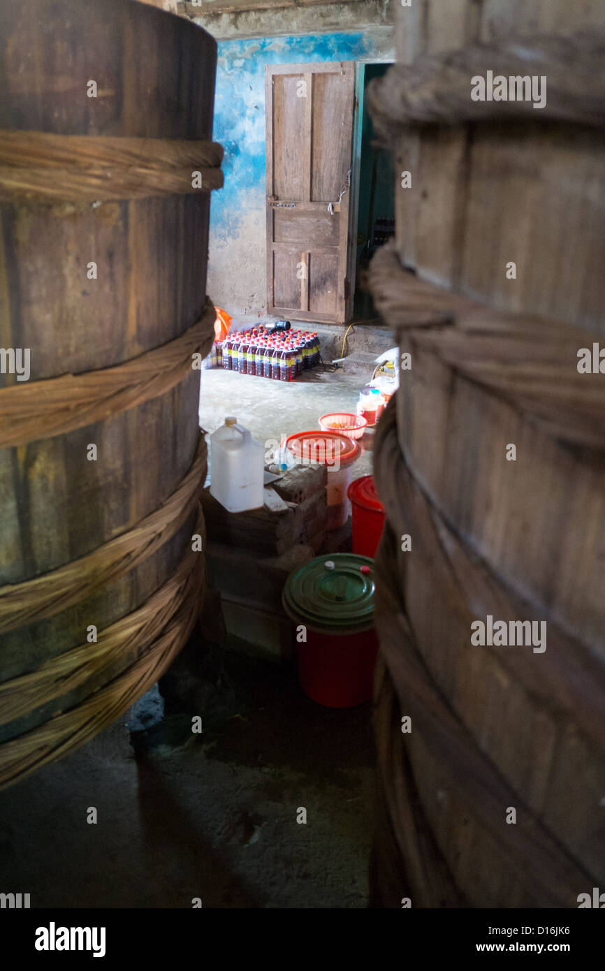 Wooden vats of fish sauce in foreground. In background bottles of ...