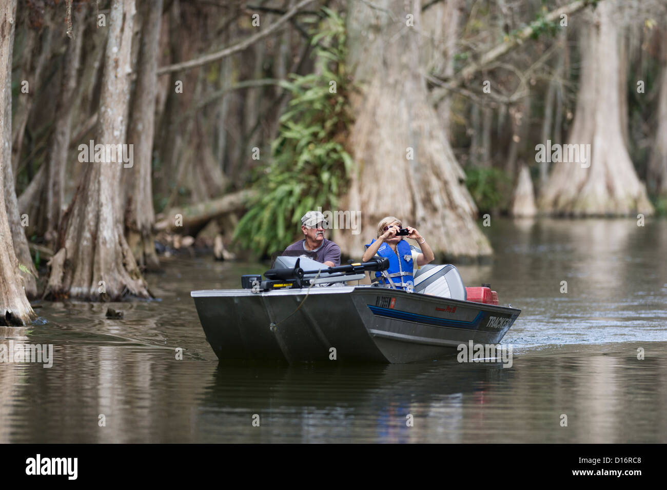 A couple boating among the cypress trees on the Mount Dora Canal in ...