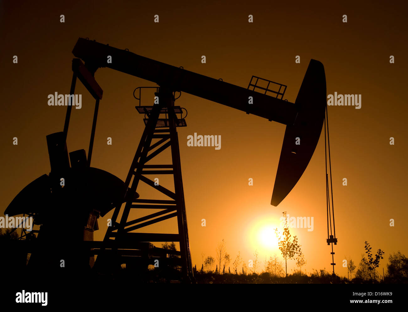 Silhouette of oil well with beautiful sunset Stock Photo - Alamy