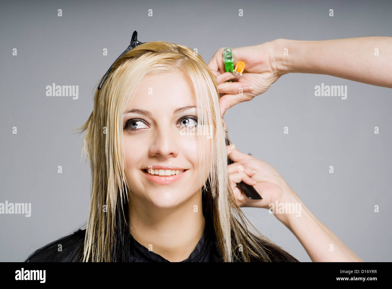 Smiling happy client while hairdresser cutting hair Stock Photo - Alamy