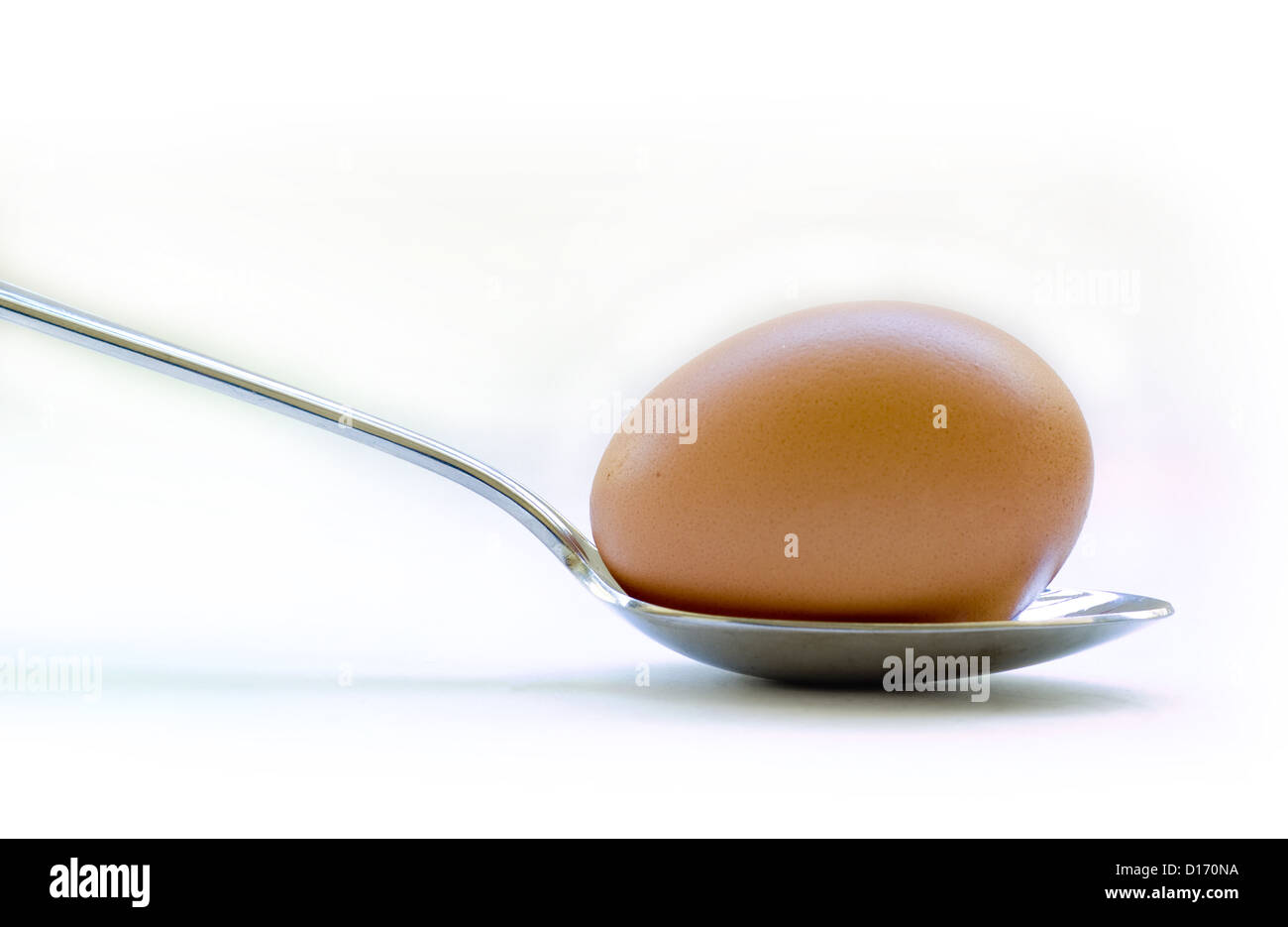 Fresh farm egg on breakfast spoon Stock Photo - Alamy