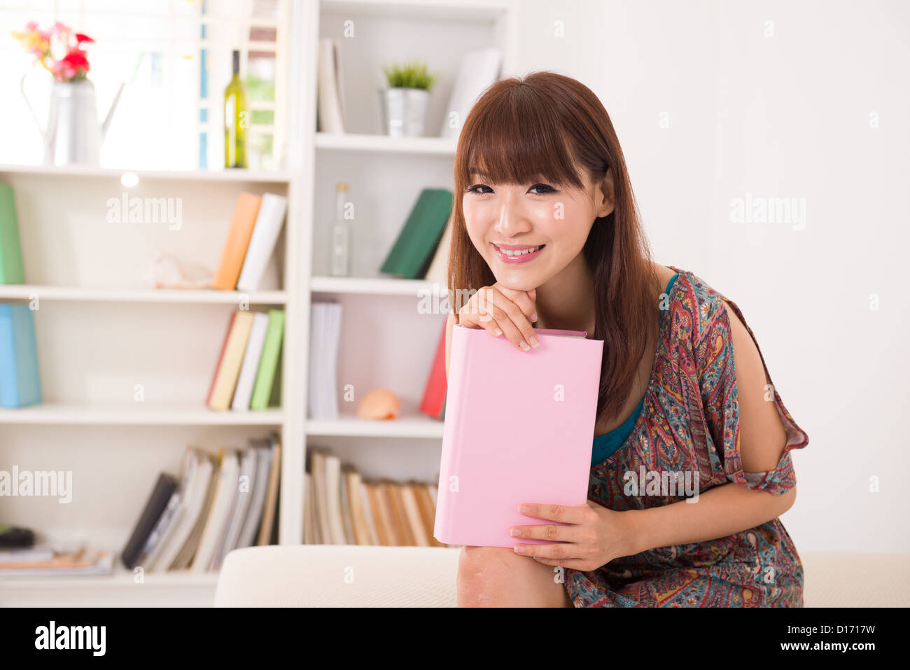 chinese girl reading on sofa Stock Photo - Alamy