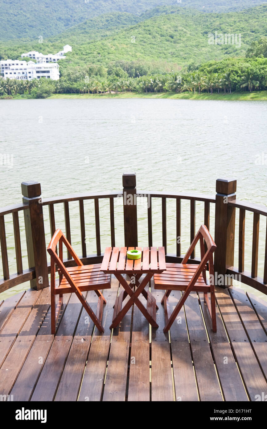 Patio with table and chairs by the riverside Stock Photo - Alamy
