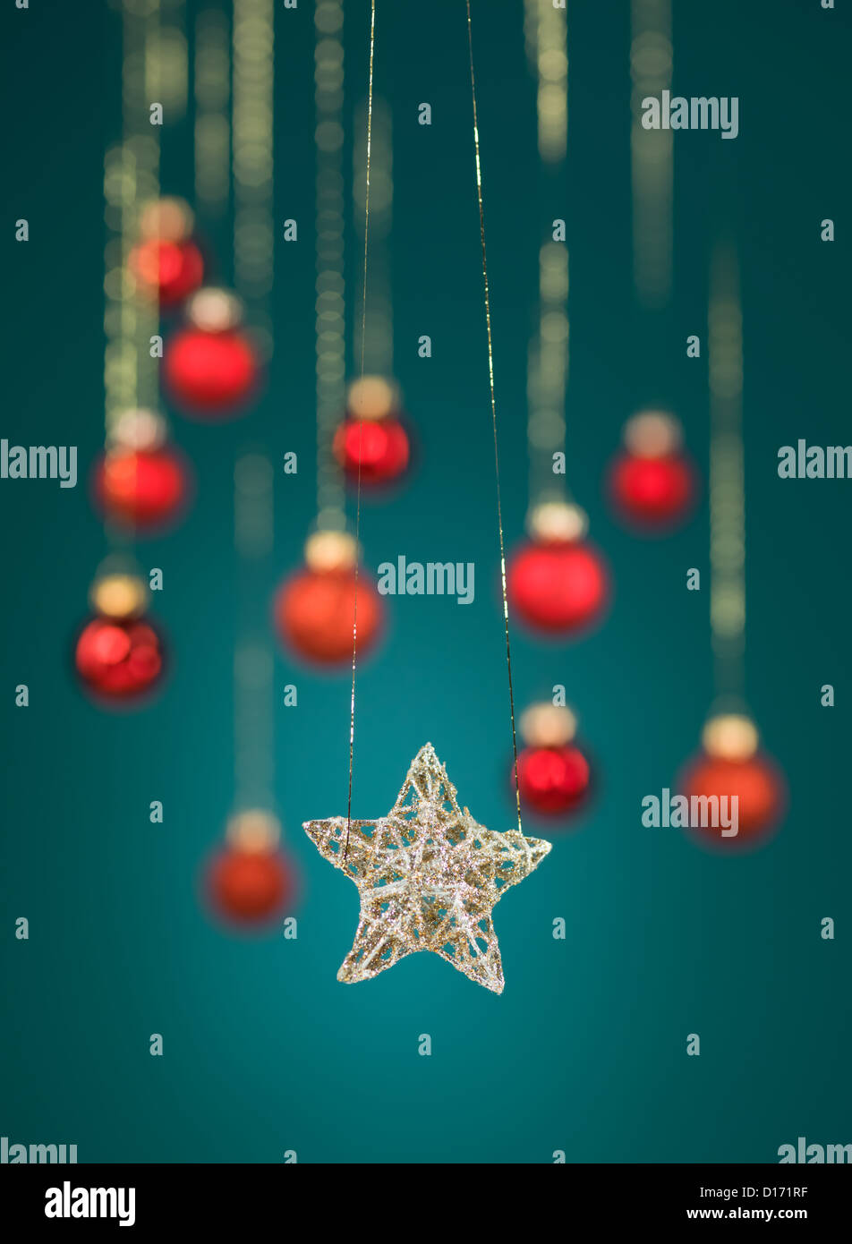 closeup of hanging glittery star with golden threads on blue gradient ...