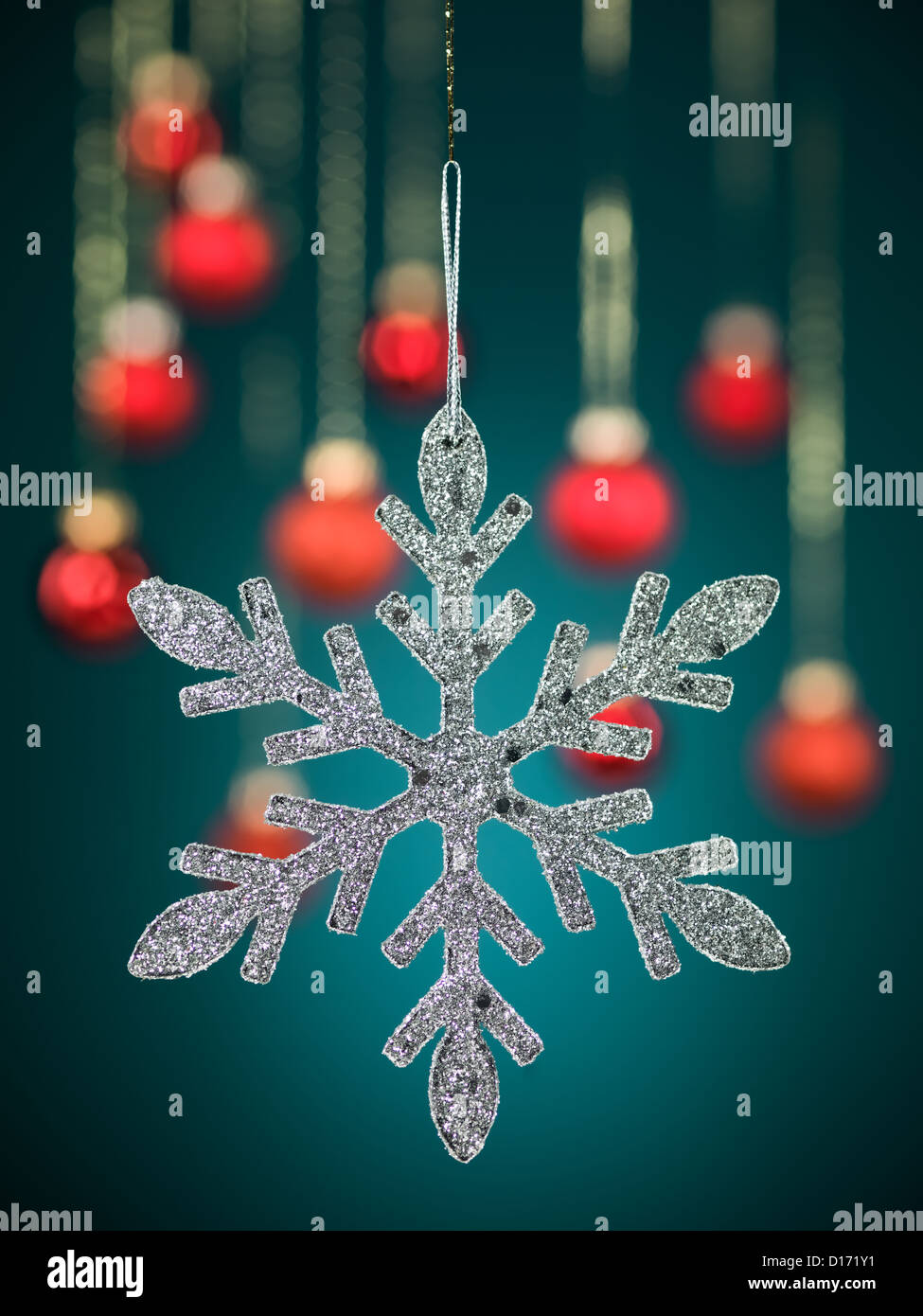 closeup of hanging christmas silver glittery snowflake, with golden ...