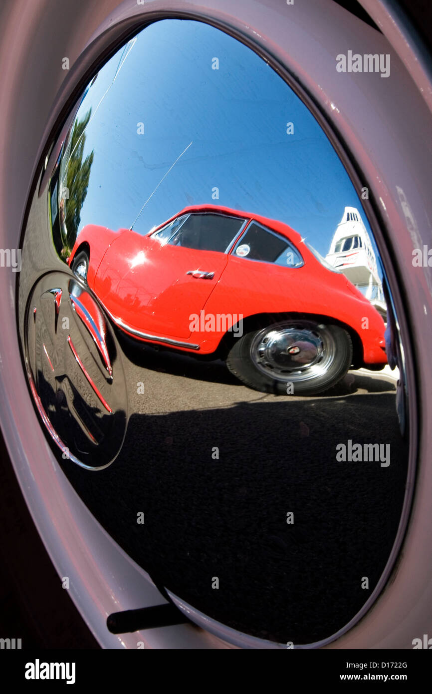 The reflection of a red classic car in a shiny chrome hubcap Stock ...