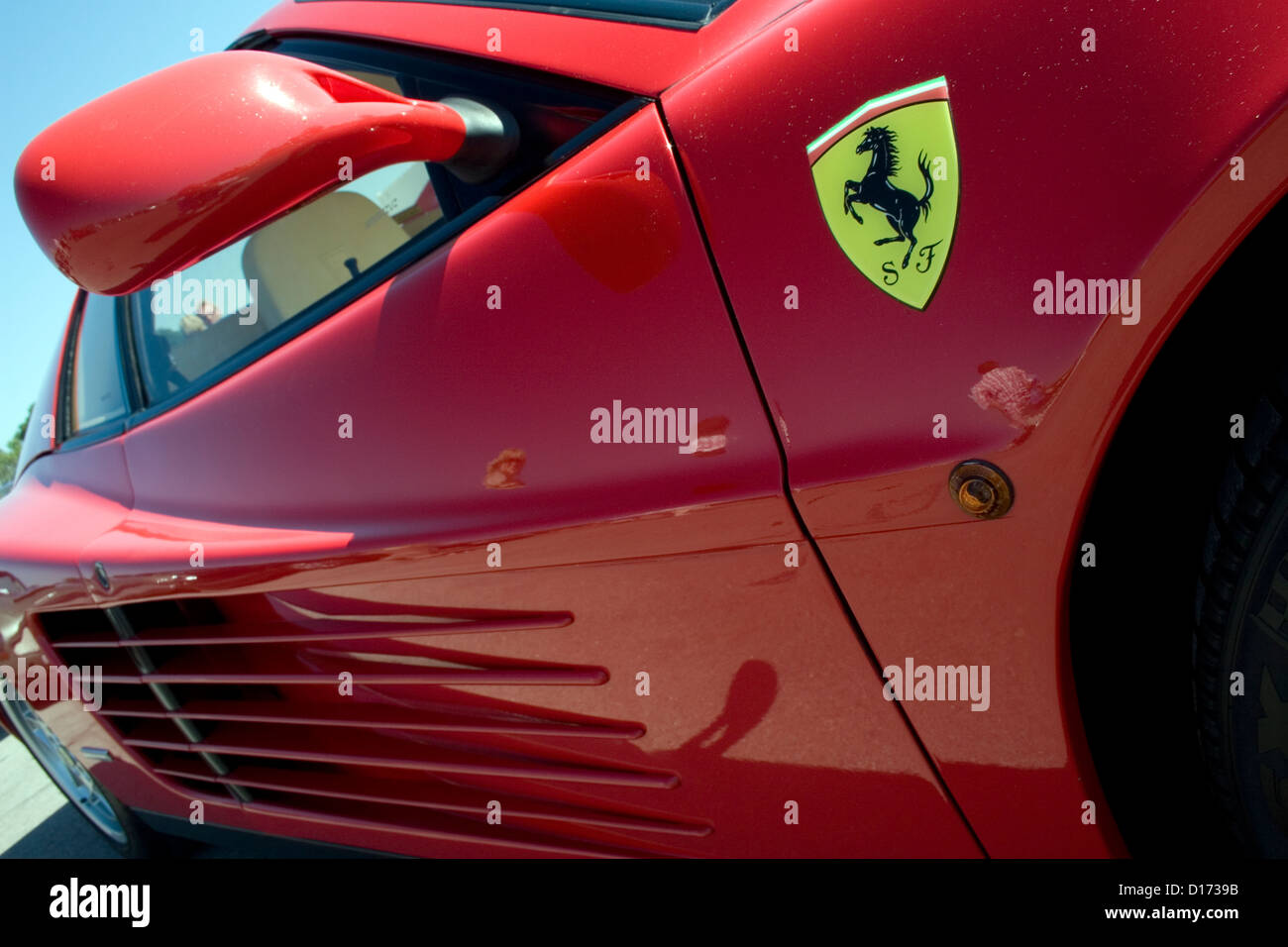 A Ferrari badge on the side of a red Ferrari supercar Stock Photo - Alamy