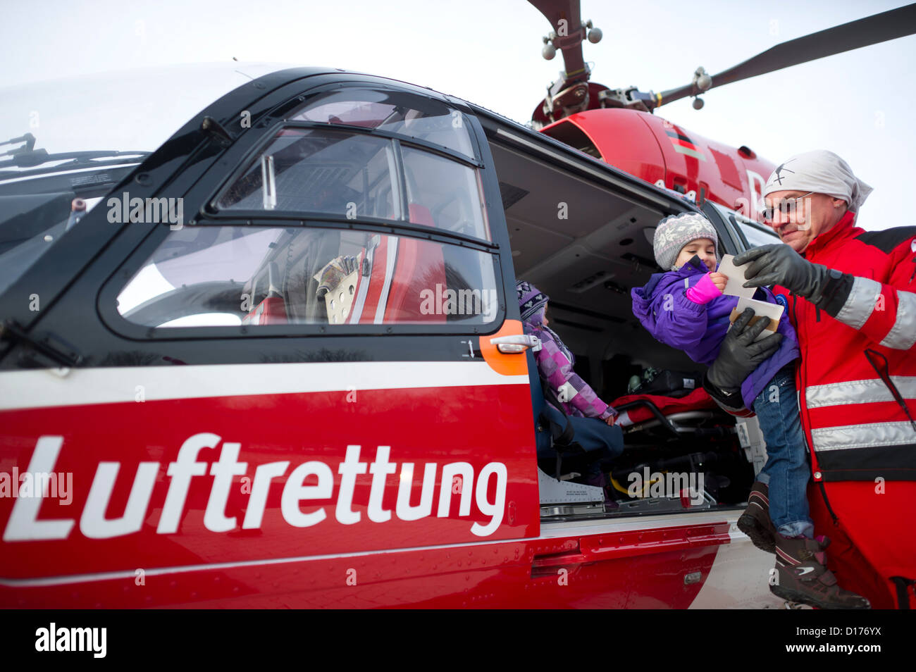 A member of the rescue by helicopter team helps a child out of a ...
