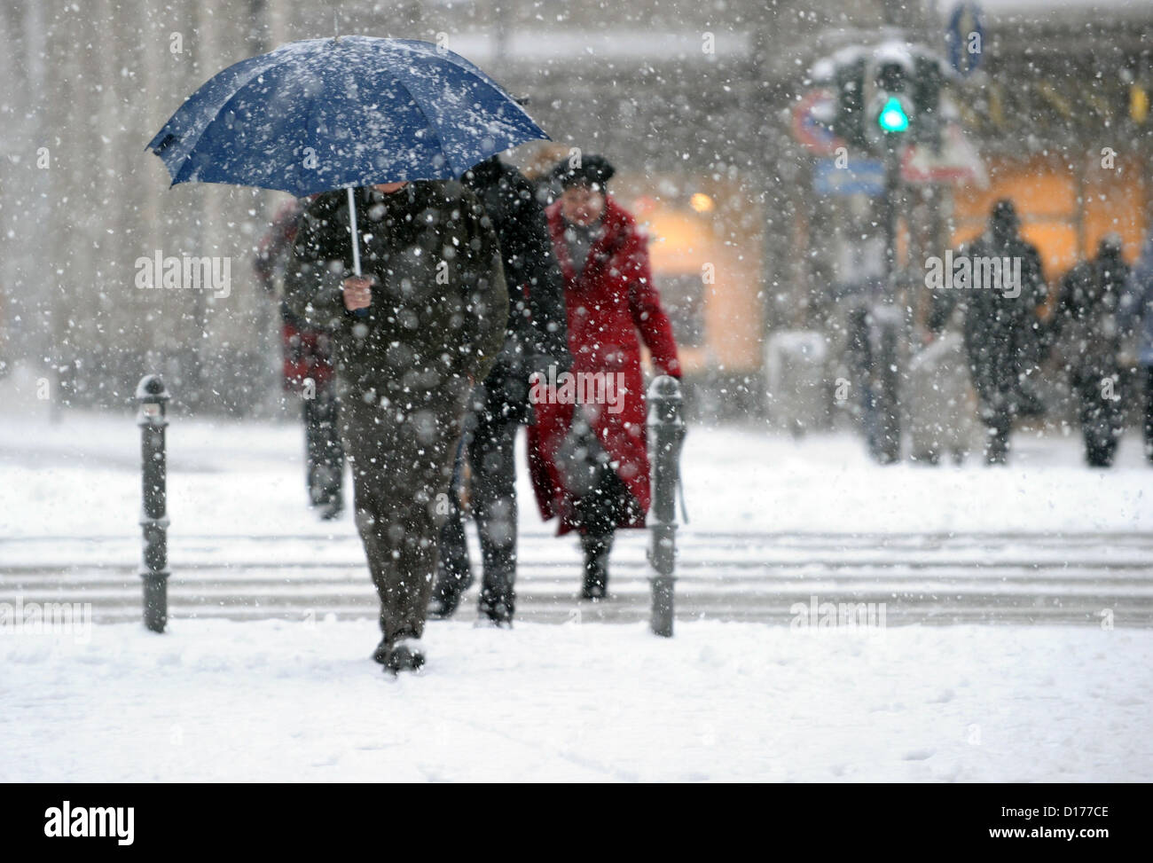 Pedestrians use umbrelaa to protect themselves from heavy snow in ...