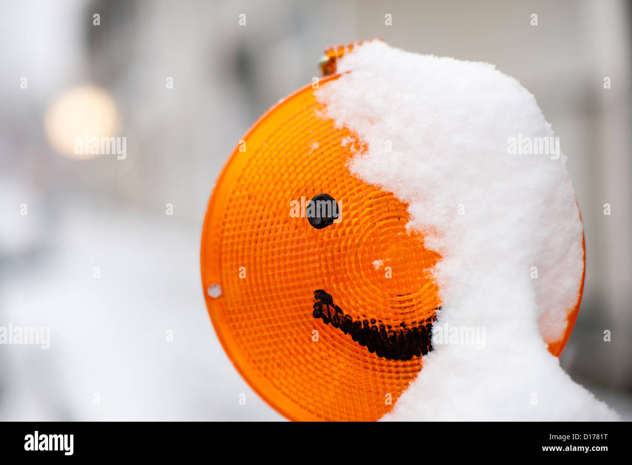 A smiley has been drawn on a constrcution site warning light, which is ...