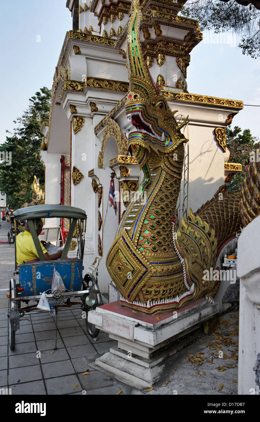 Thailand, Chiang Mai, a rickshaw parked by a religious dragon statue ...