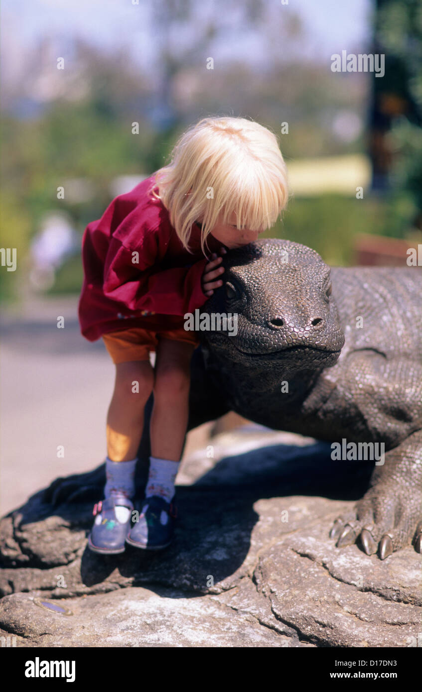 Young girl kissing giant lizard statue Stock Photo - Alamy