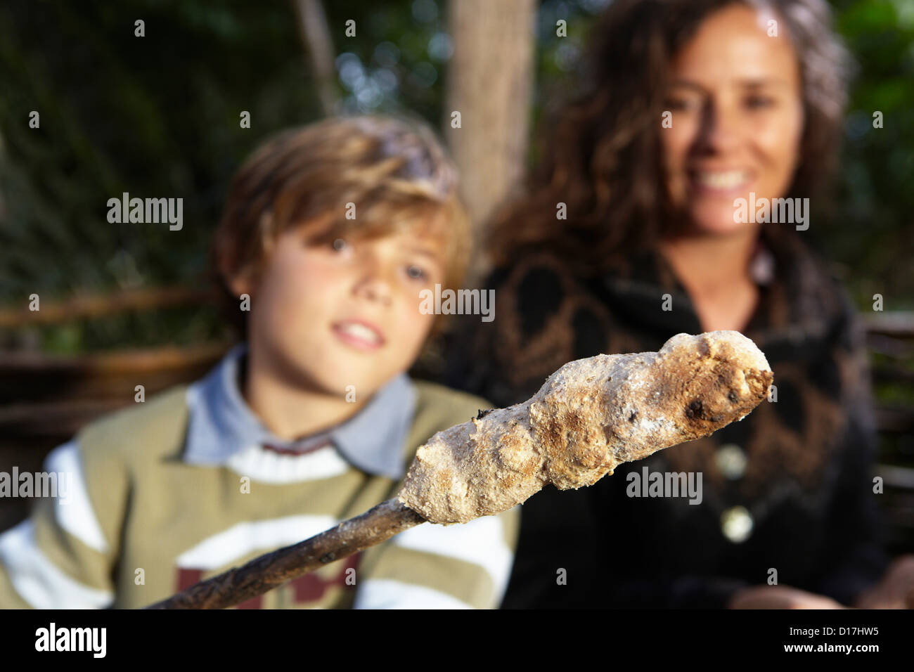 Boy cooking bread over fire Stock Photo - Alamy
