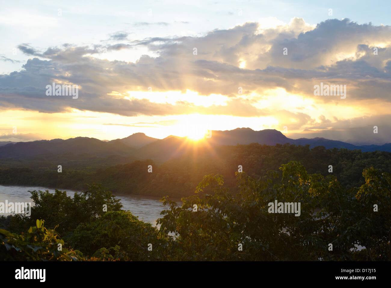 Sun rising over mountain range Stock Photo - Alamy