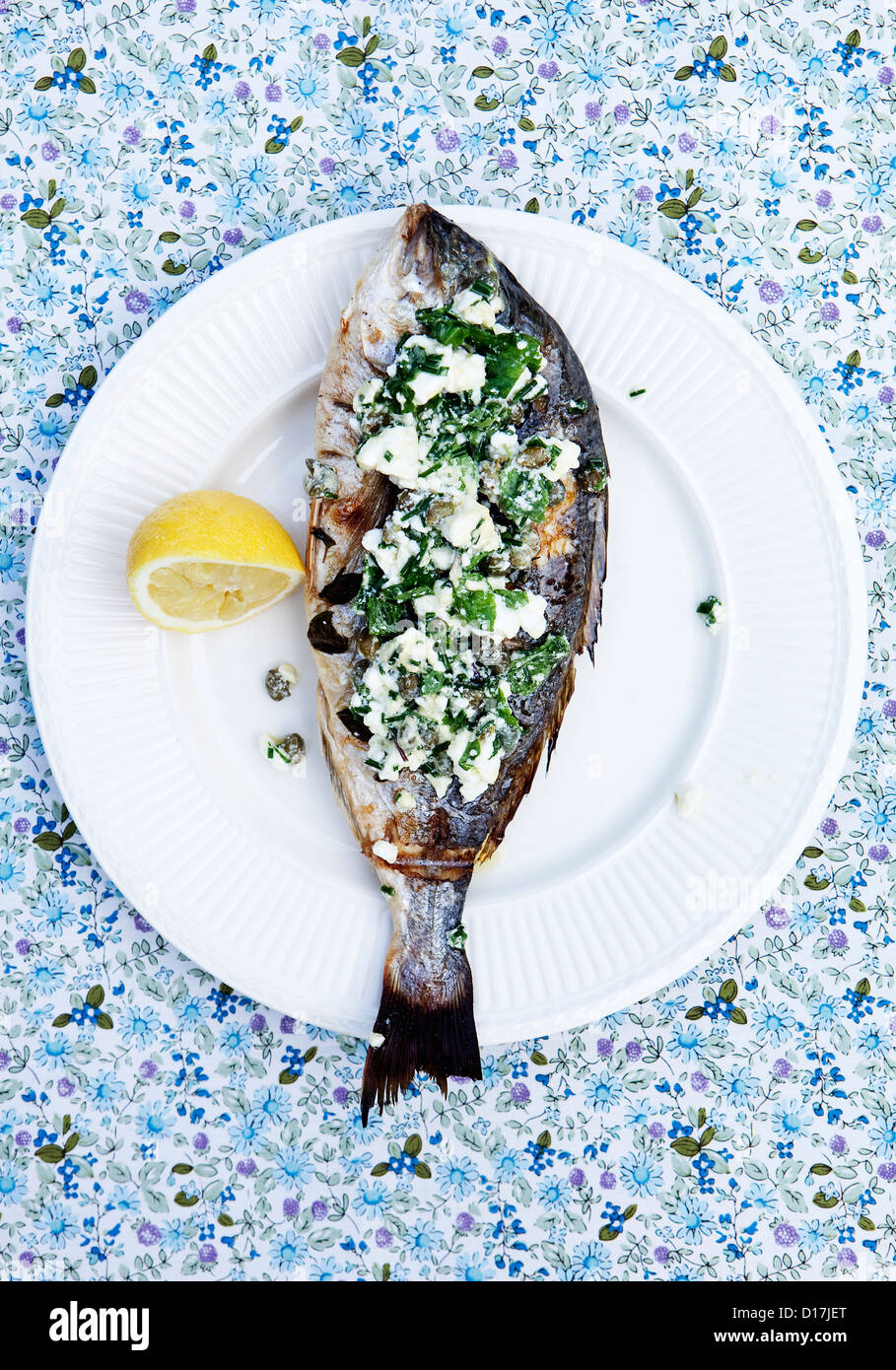 Plate of fish with herb topping Stock Photo - Alamy