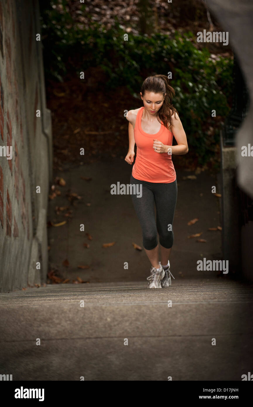 Woman running on city street Stock Photo - Alamy