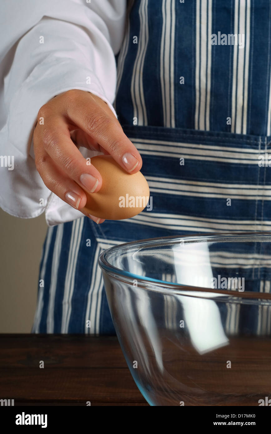 Woman chef or cook breaking egg into kitchen mixing bowl Stock Photo ...