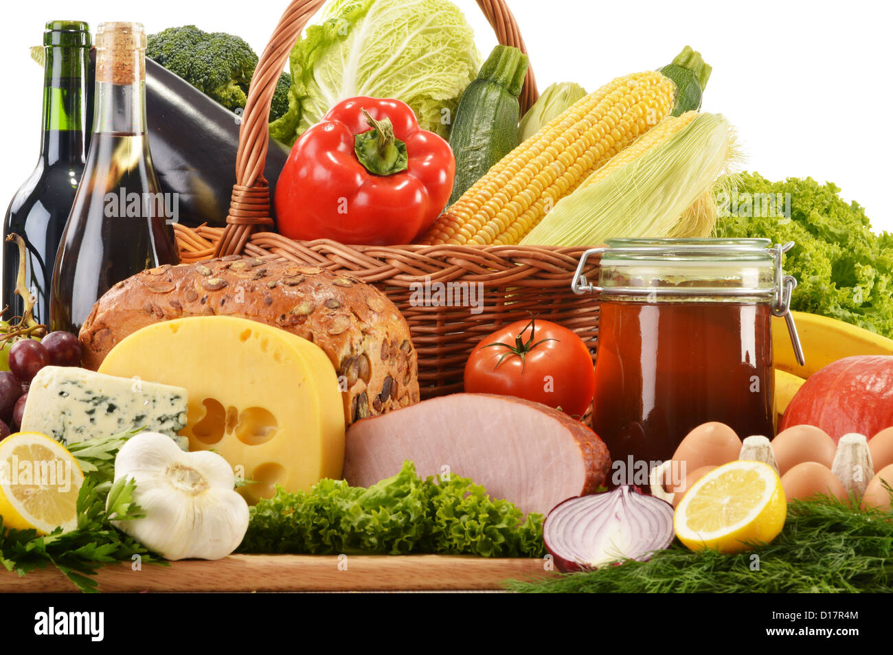 Composition with groceries in wicker basket on kitchen table Stock ...