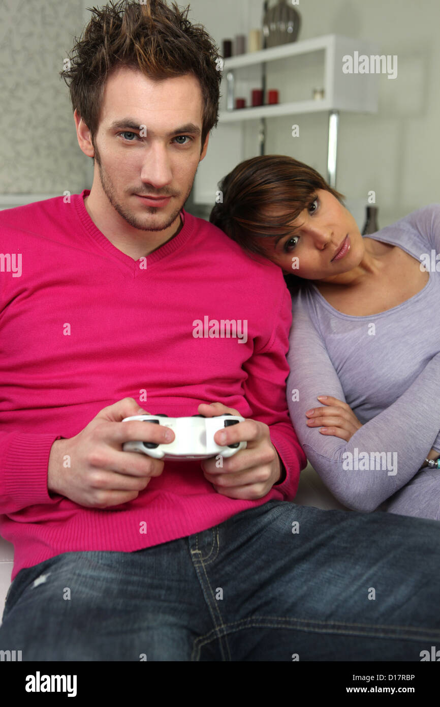 Woman watching boyfriend play video-games Stock Photo - Alamy