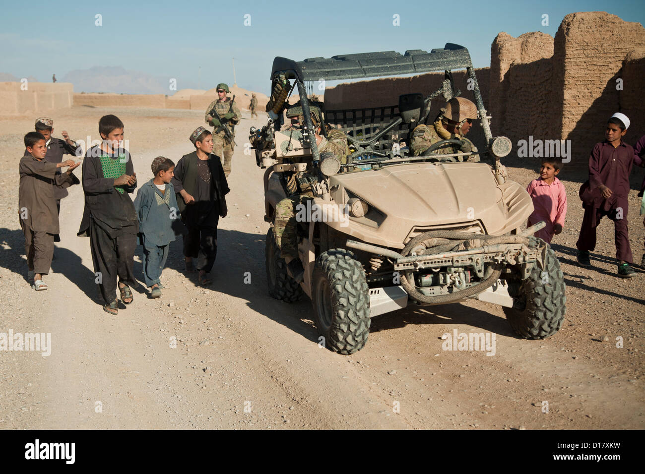 Children run alongside a light-tactical ATV as US Special Forces patrol ...