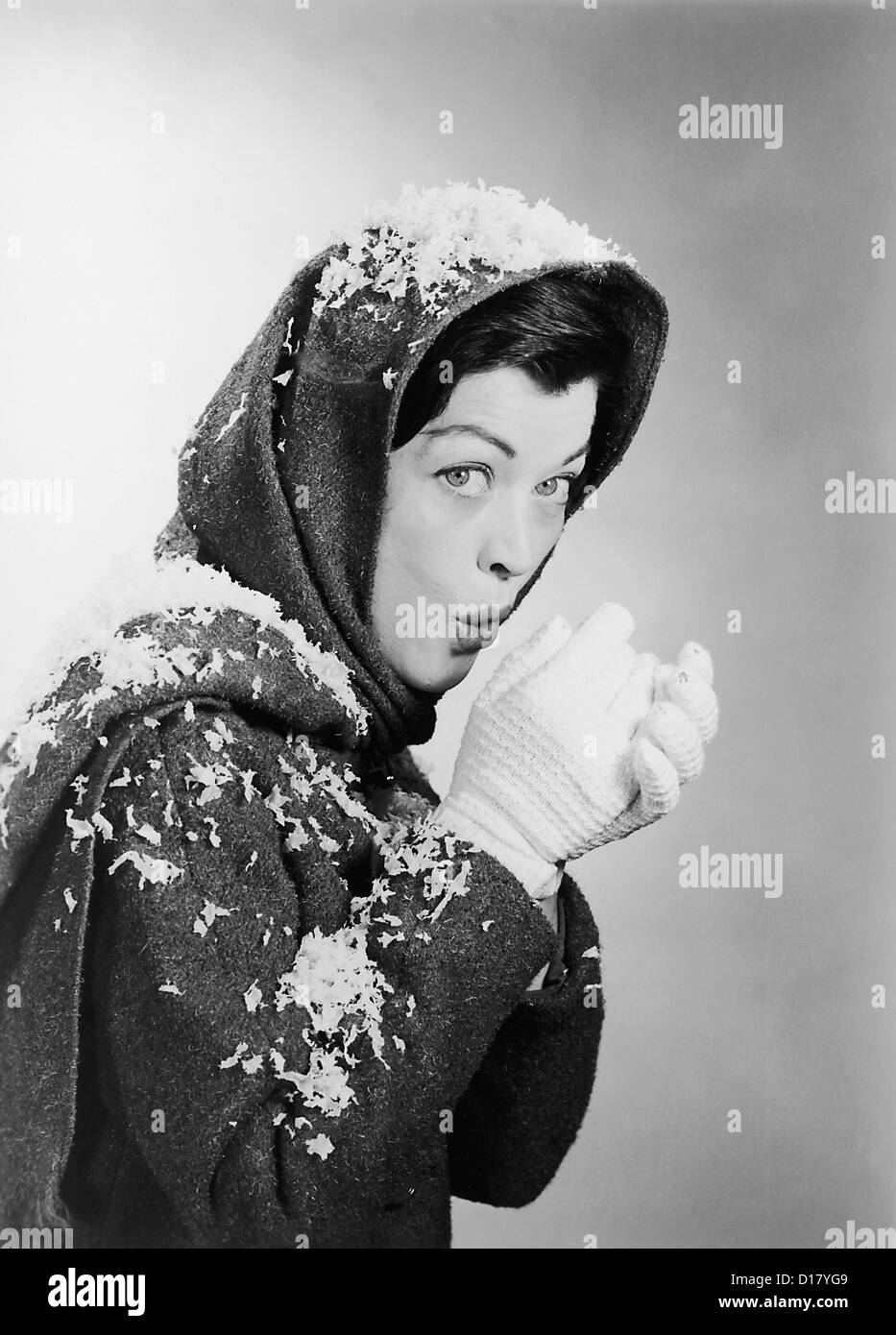 Portrait of woman bundled up, blowing on her hands Stock Photo - Alamy