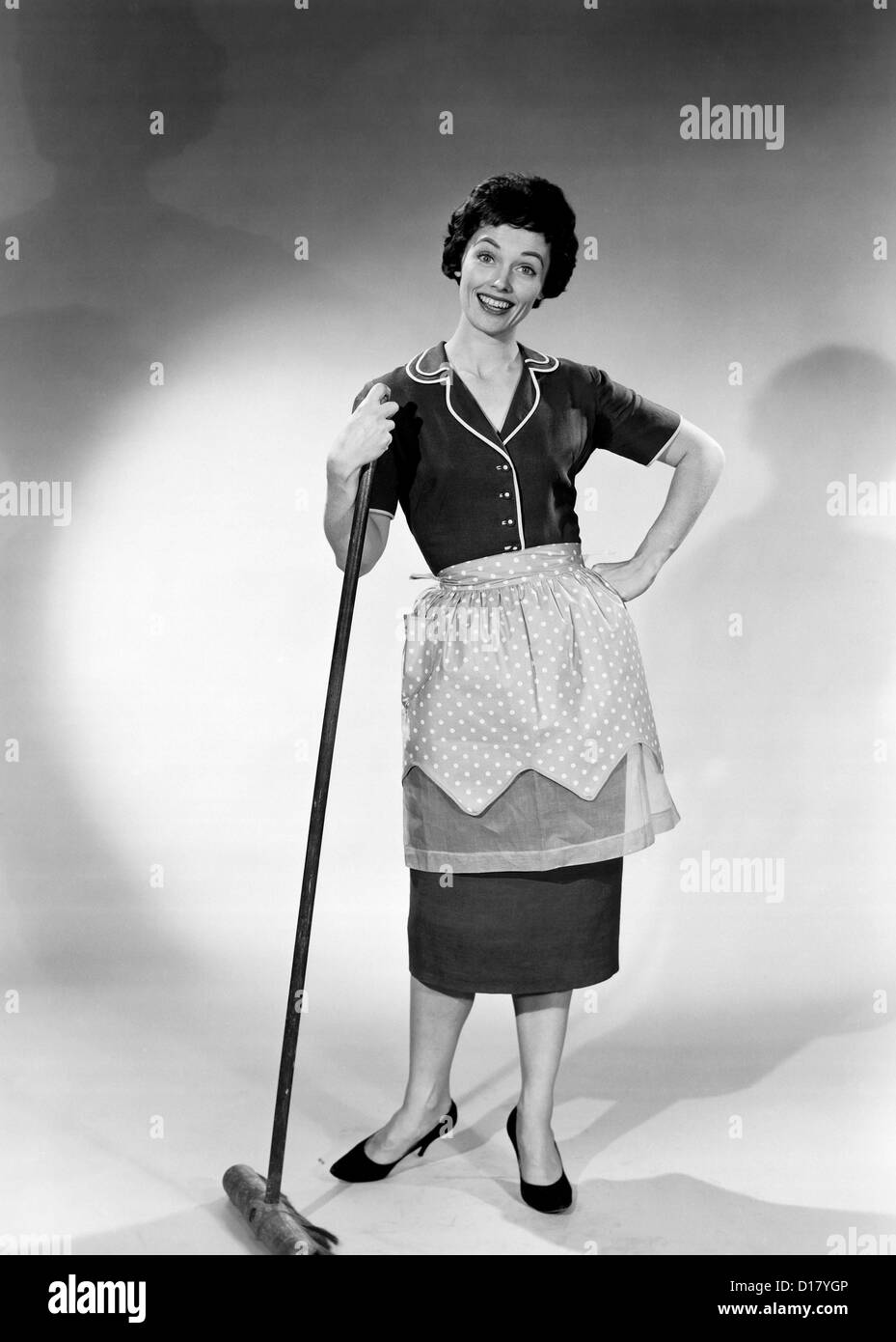 Portrait of a woman holding a broom Stock Photo - Alamy