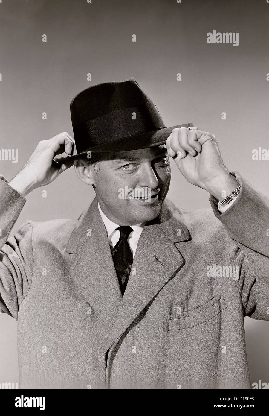 Portrait of mature man putting on hat Stock Photo - Alamy