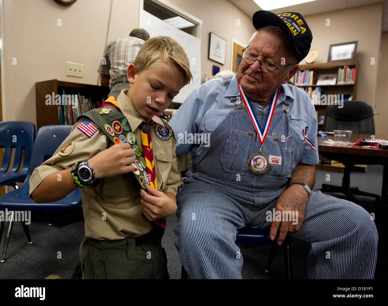 13 year old boy scout, shows elderly white male veteran, his merit badges during a Veteran's Day ...