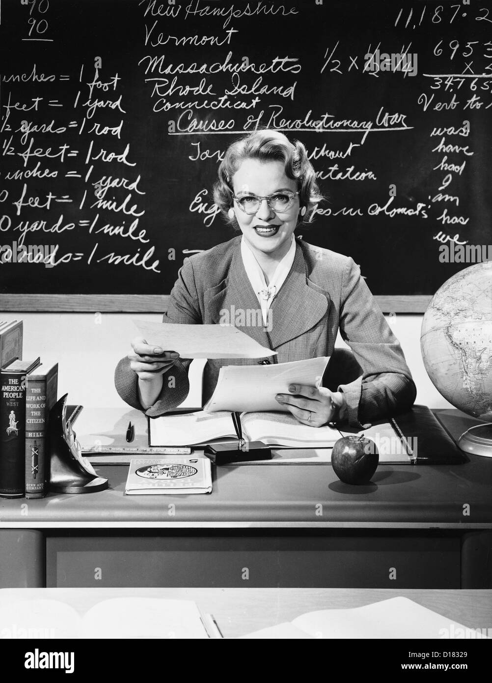 Portrait of teacher sitting at desk, 1950's, (B&W Stock Photo - Alamy