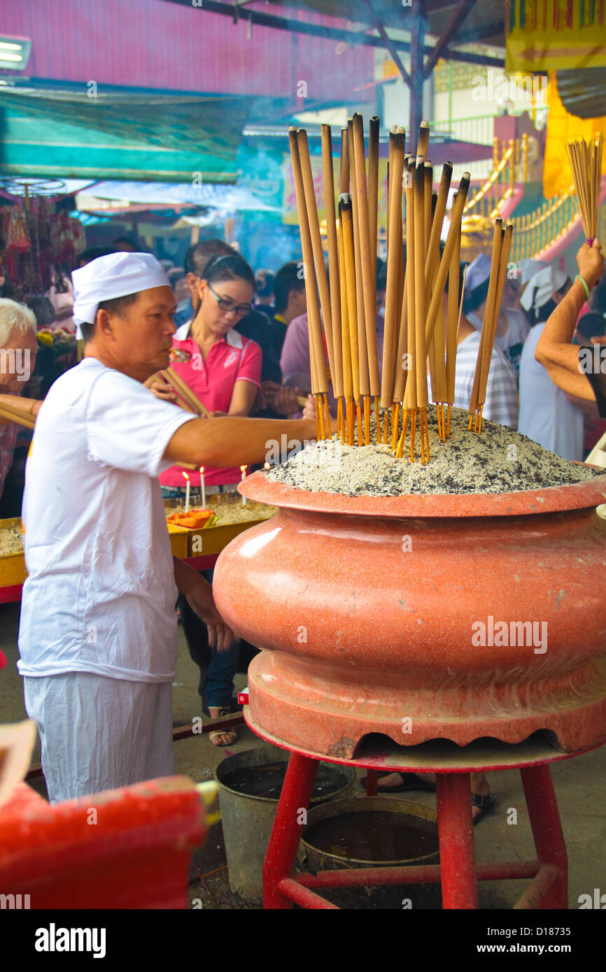 Temple worker removing joss stick from the incense furnace Stock Photo ...