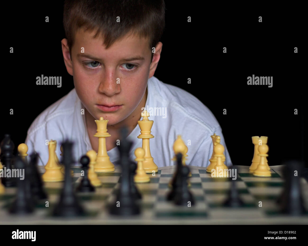 Boy playing chess on black background Stock Photo - Alamy