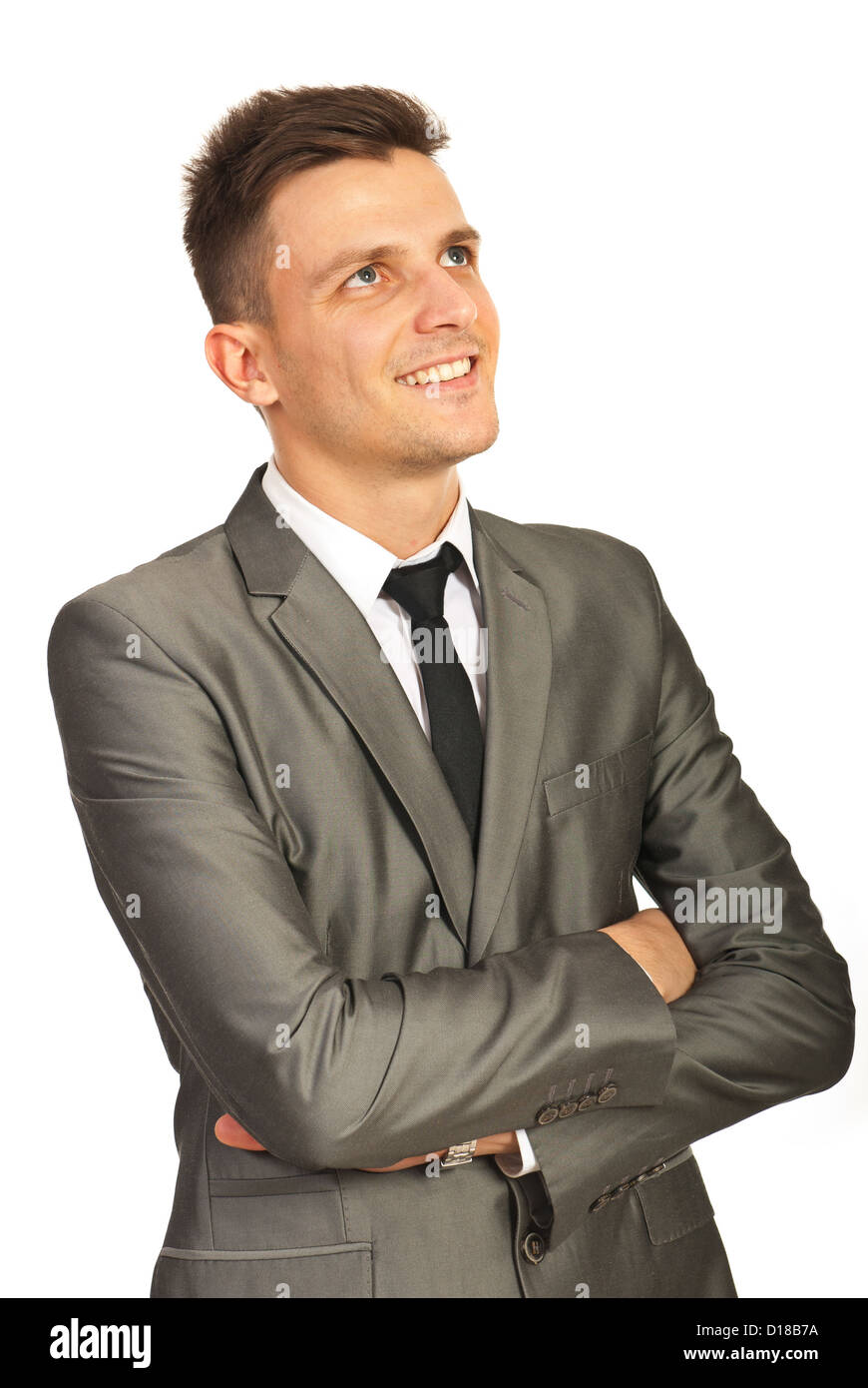 Happy executive man looking up and standing with arms folded isolated ...