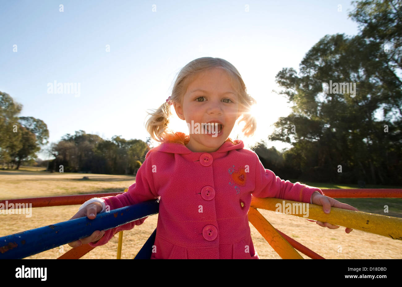 Happy young girl child play on roundabout in park Stock Photo - Alamy