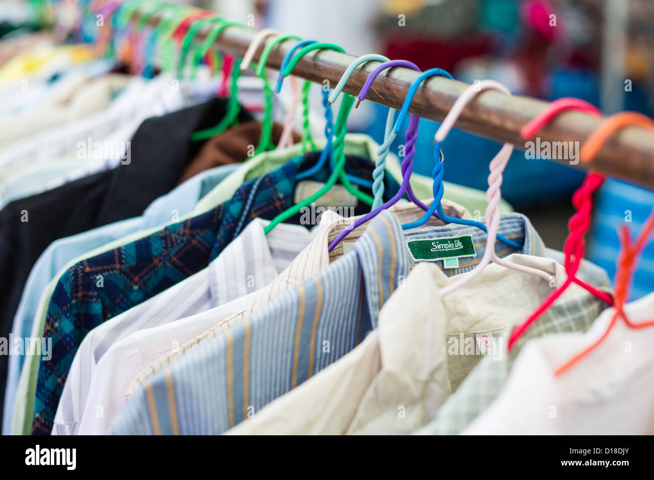 Old shirt hanging on plastic hangers in second hand market Stock Photo ...
