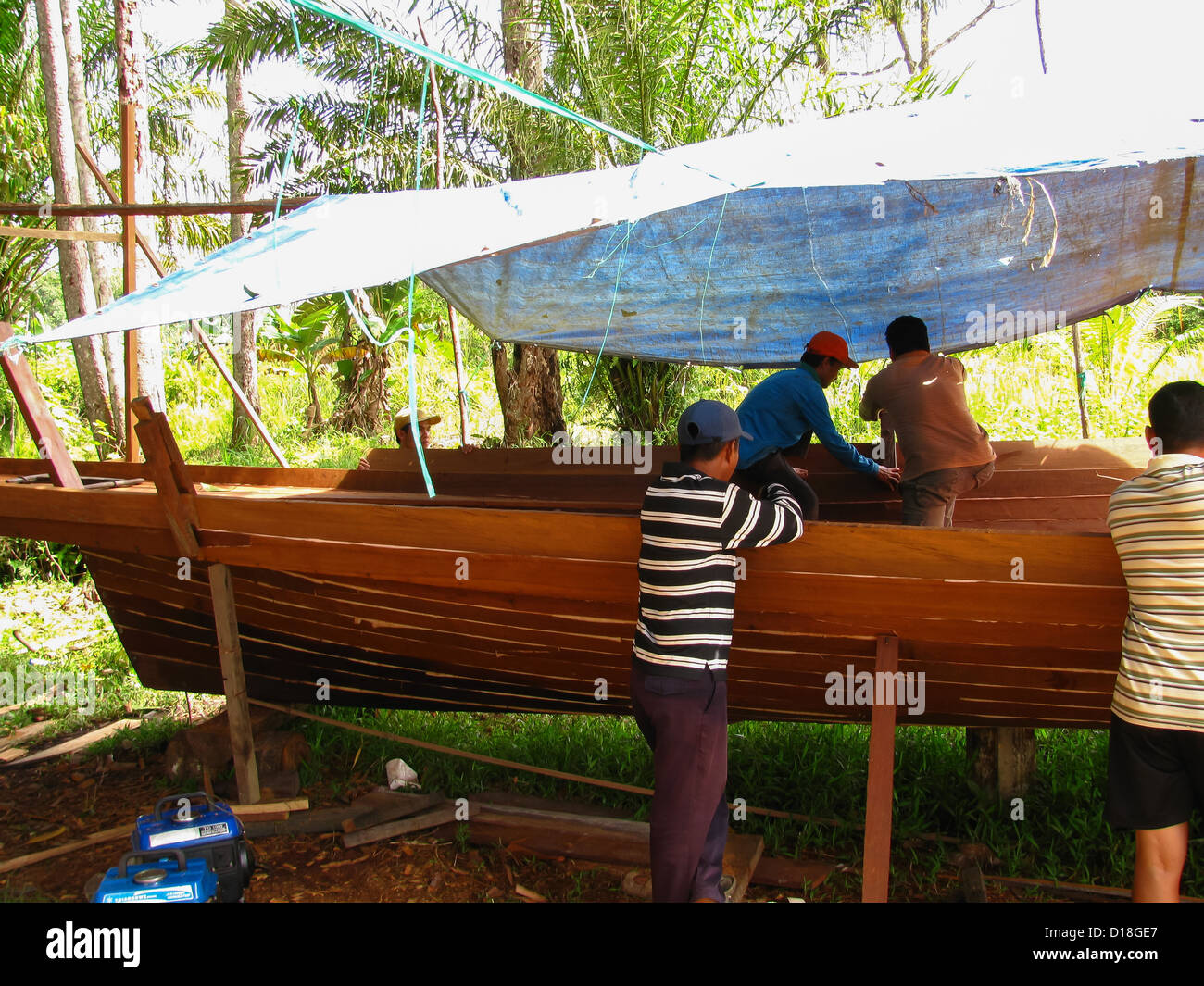Men constructing a traditional boat made of wood as means of river ...