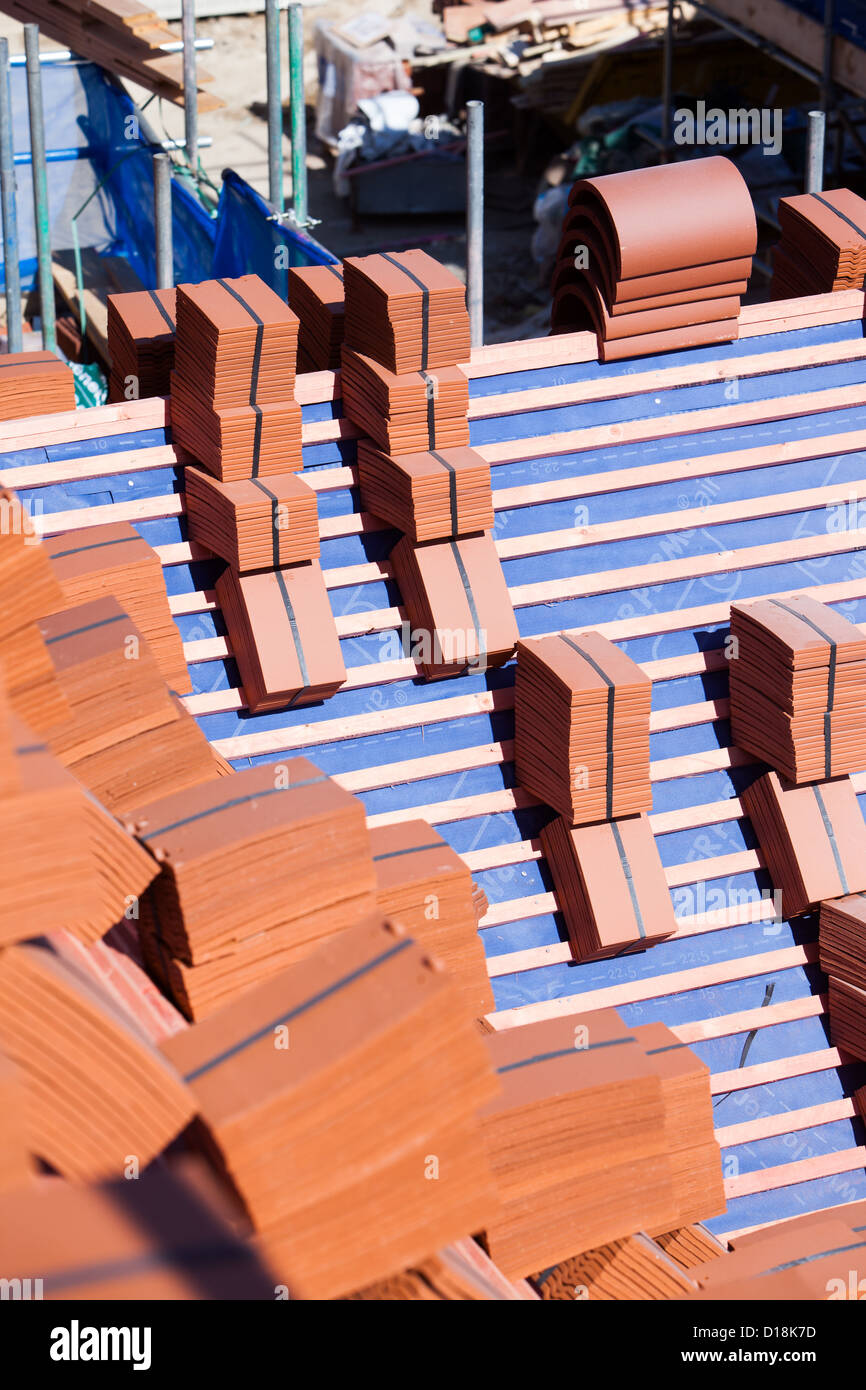 Stacks of red roof tiles balanced on a roof under construction Stock ...