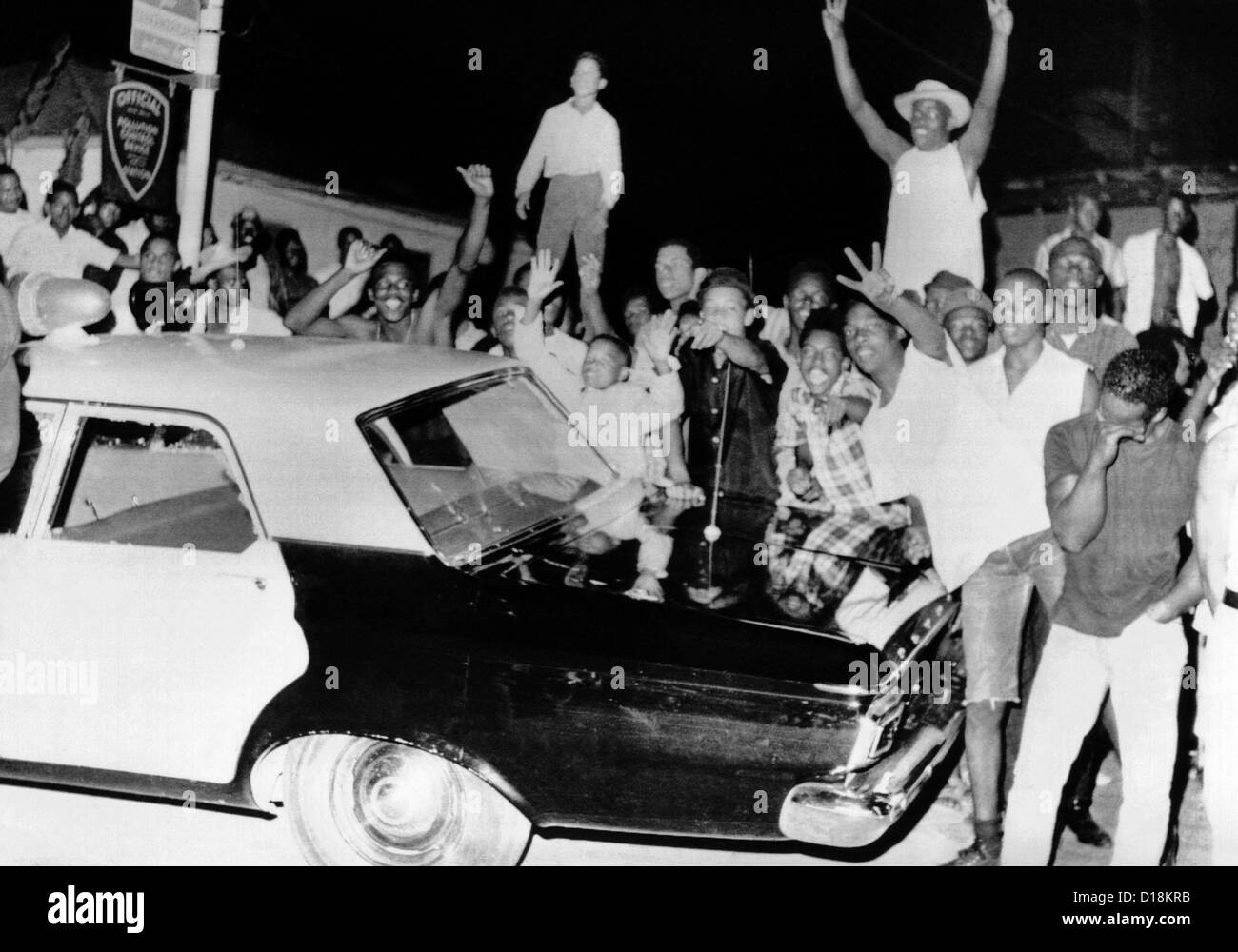 African American jeer police during the 1965 Watts Riots. Young men ...