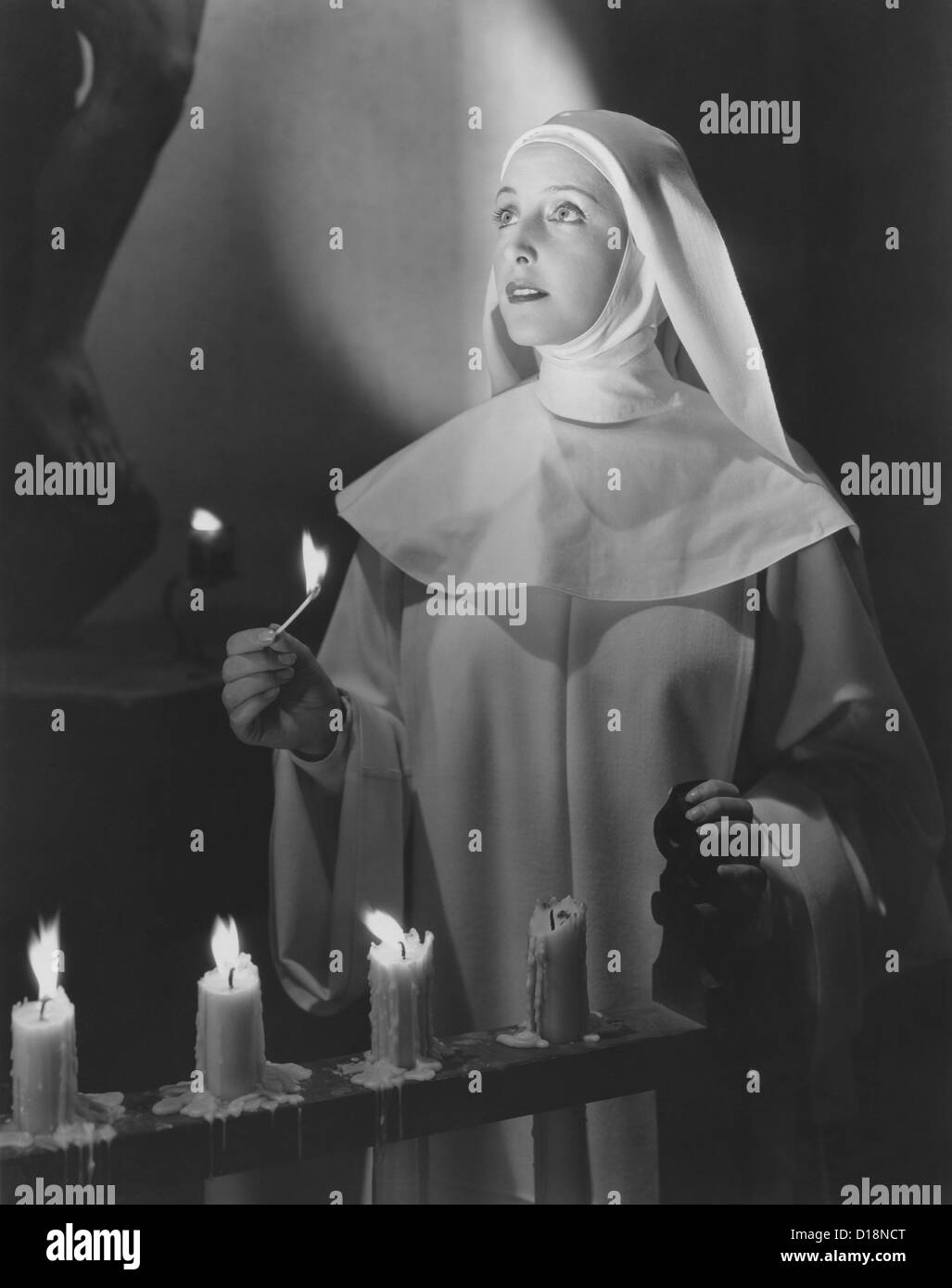 Nun lighting candles in church Stock Photo - Alamy