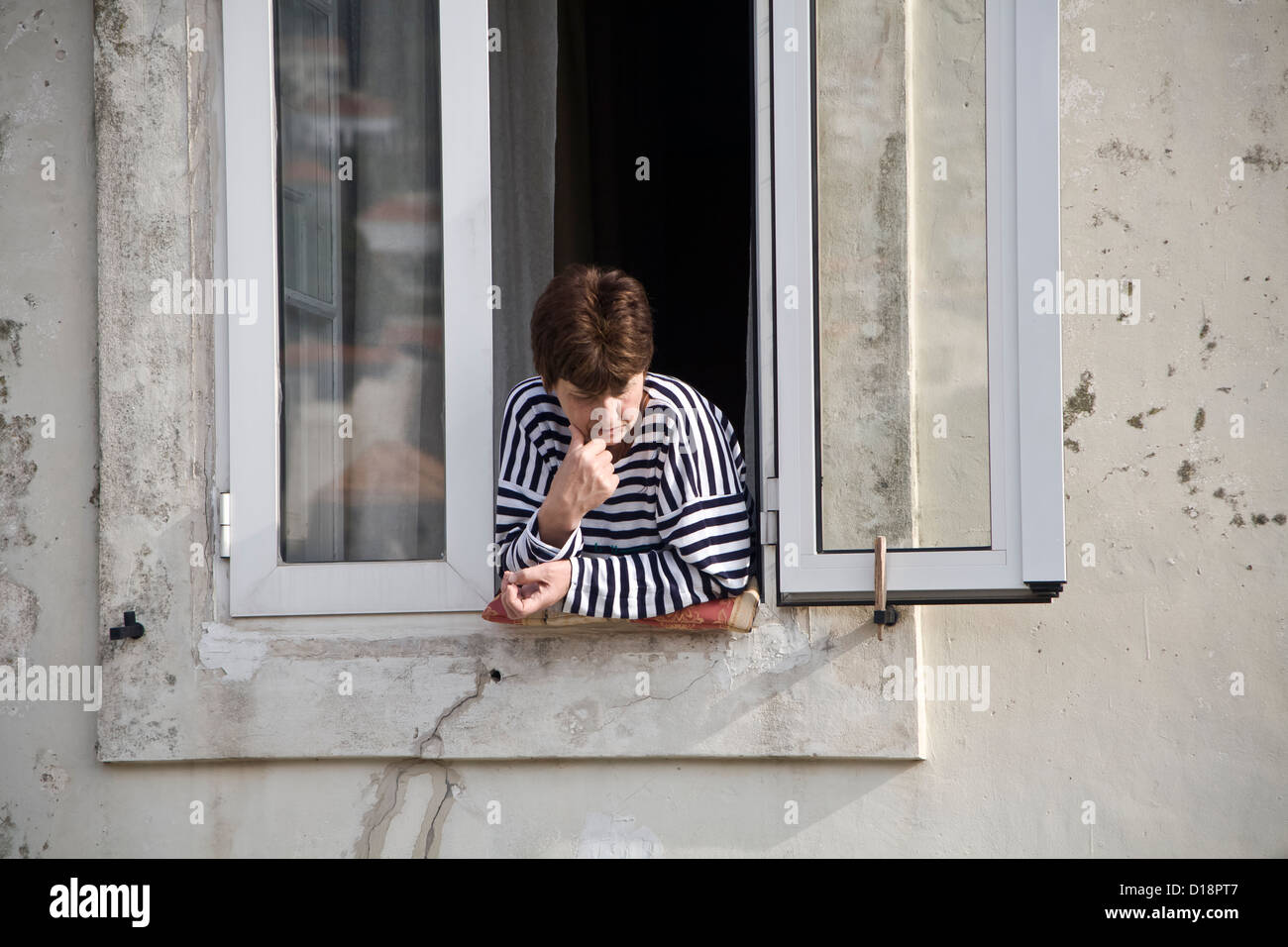 Woman looking down to street from open window in Dubrovnik Stock Photo ...