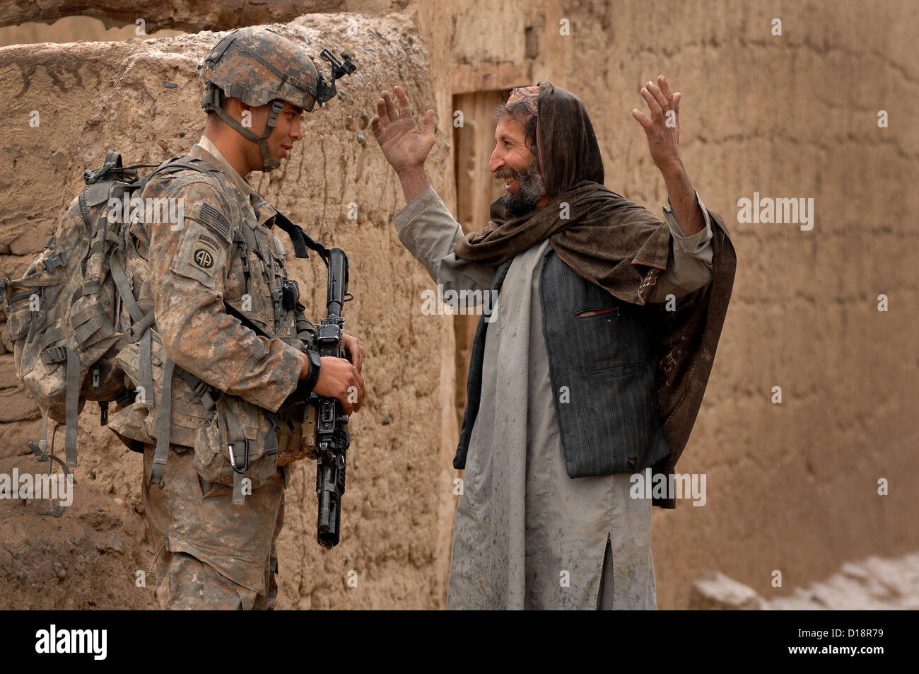 US Army soldier talks with a village resident during a joint operation ...