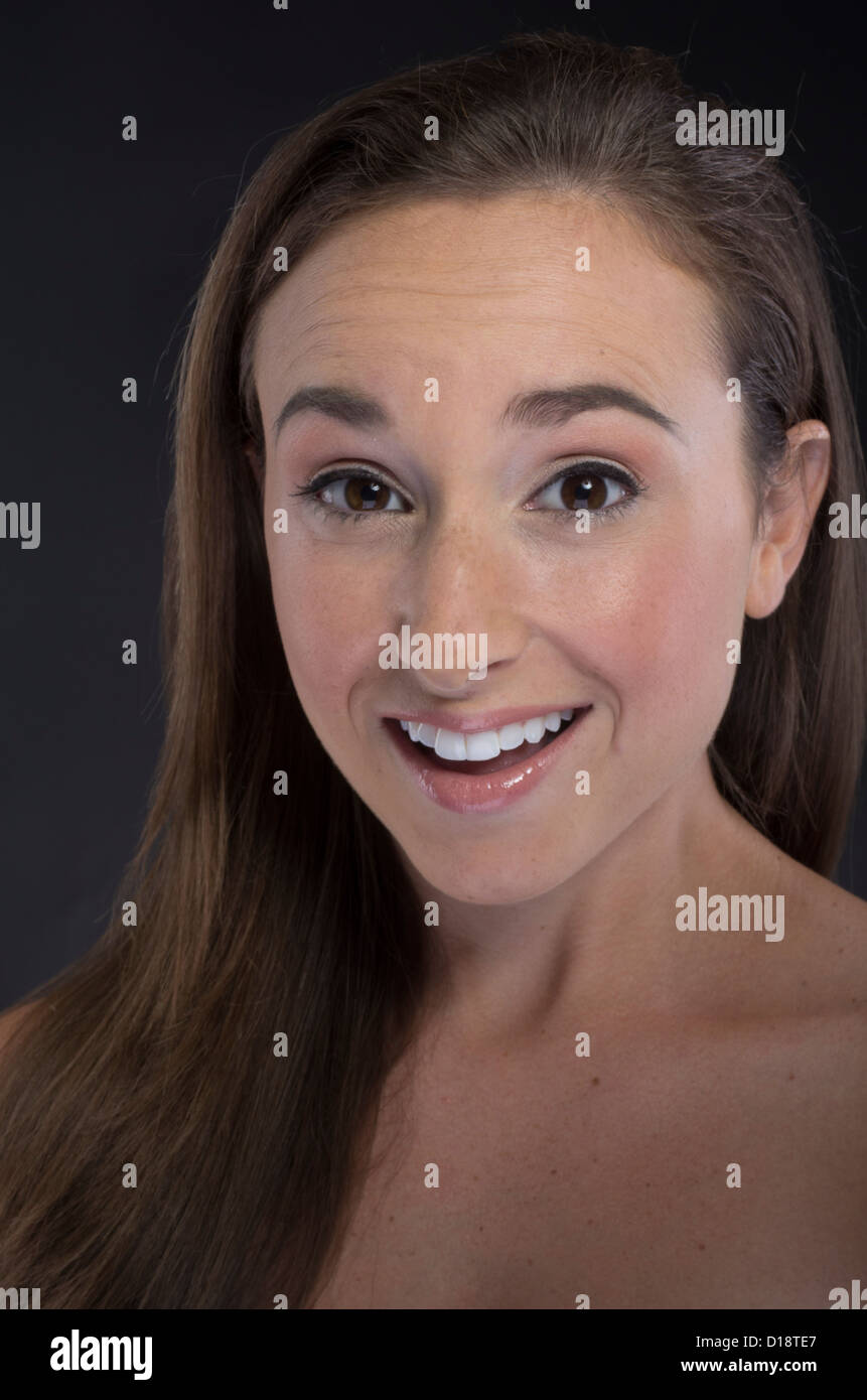 Young woman with a nervous smile Stock Photo - Alamy